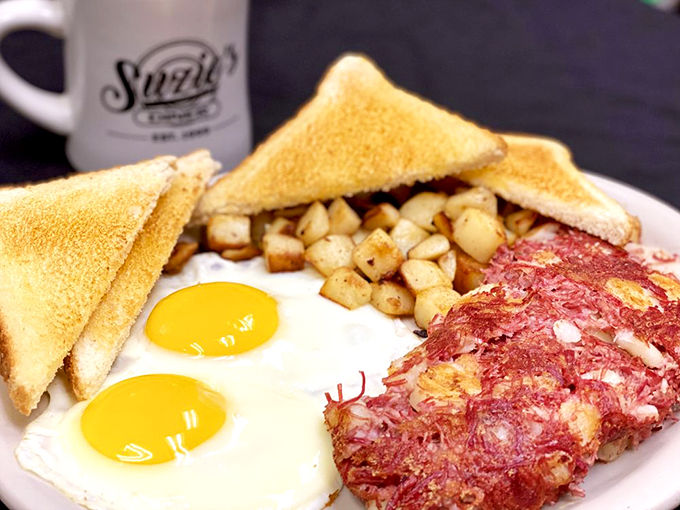 A breakfast that means business: sunny-side-up eggs, crispy home fries, and corned beef hash waiting to jump-start your day.