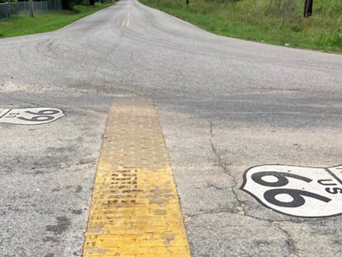 Where Missouri tips its hat to Kansas. This humble painted emblem on weathered pavement marks transitions between worlds.