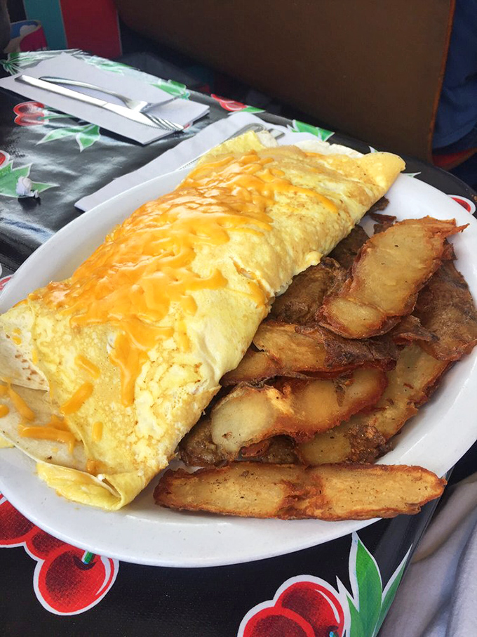 An omelet that refuses to be contained by conventional boundaries, spilling cheese like sunshine across the plate. Breakfast manifest destiny at its finest. 