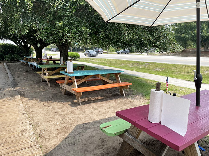 Colorful picnic tables under shade trees—where memories are made between bites of the best fish sandwich on the Crystal Coast.