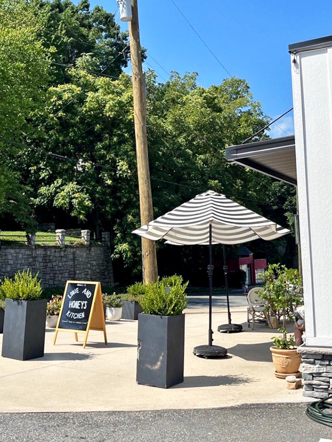 Even the outdoor space invites lingering. The striped umbrella and chalkboard sign say "stay awhile" in the international language of hospitality.