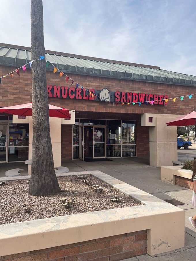 Colorful pennants flutter above the entrance like a permanent celebration. When sandwiches are this good, every day is a festival.