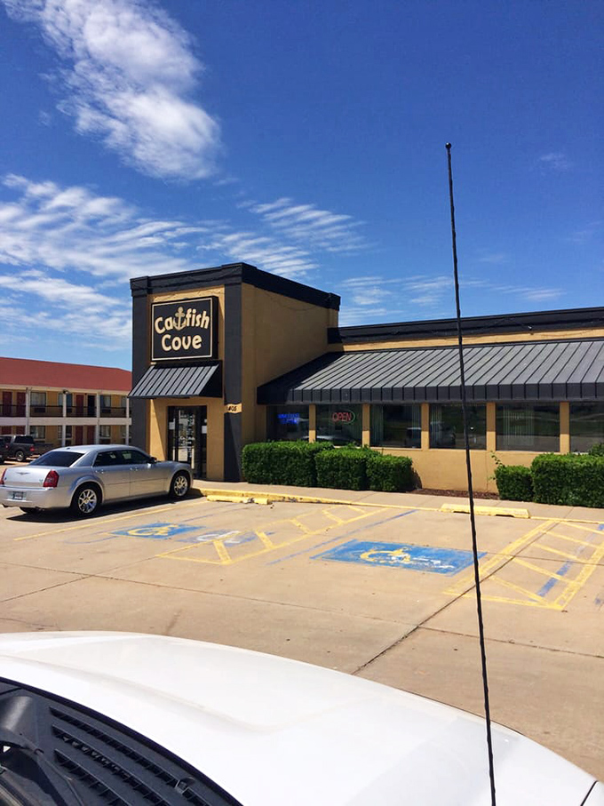 The Catfish Cove sign stands proud against Oklahoma's big blue sky. Cars in the lot represent pilgrimages from across the state for seafood salvation.