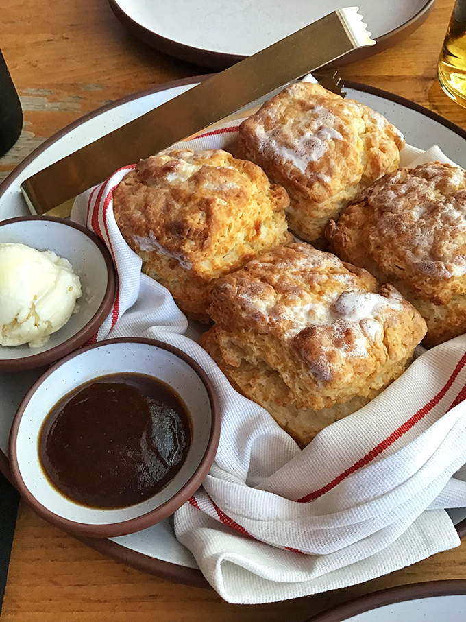Biscuits so perfectly golden they deserve their own suntan lotion endorsement. Served with butter and jam, they're Southern comfort in carb form.