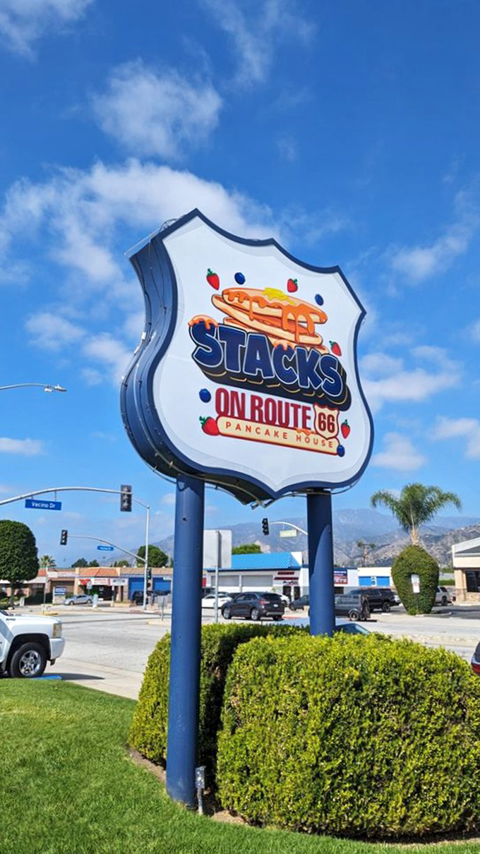 Like a beacon to the breakfast-starved, this shield-shaped sign stands tall against the California sky, promising pancake salvation ahead.