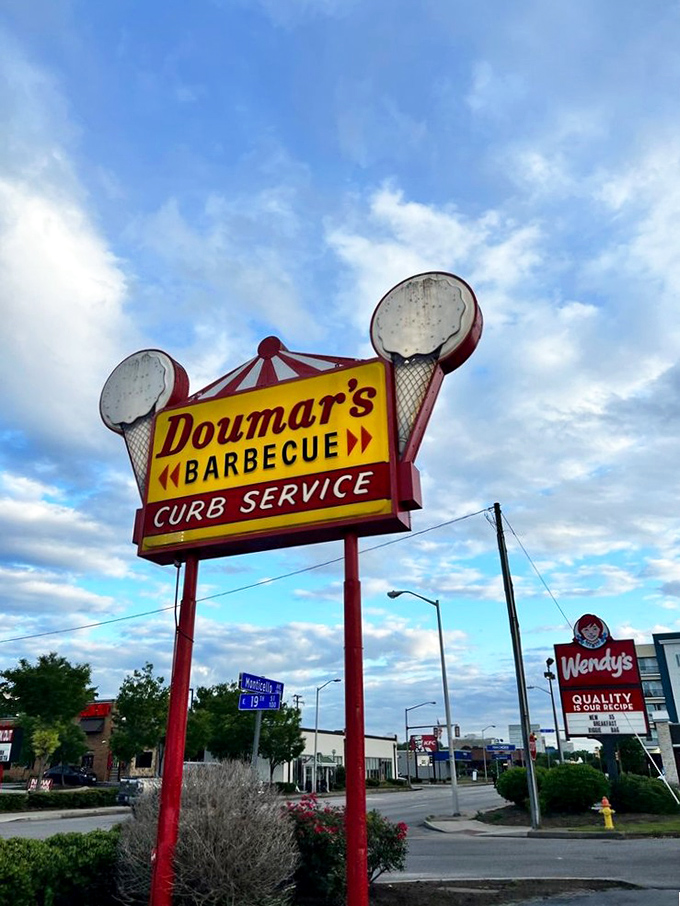 The sign says it all&mdash;ice cream cones flanking "Doumar's Barbecue" with "CURB SERVICE" proudly proclaimed below, a neon promise of good times against Norfolk's big sky.