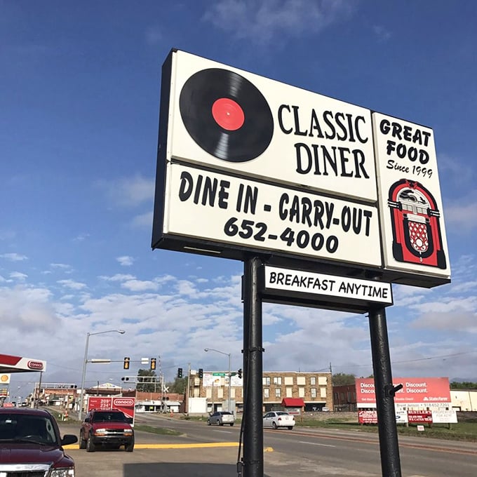 The roadside sign stands tall against Oklahoma skies, a beacon of hope for hungry travelers and a reminder that breakfast knows no time constraints here.