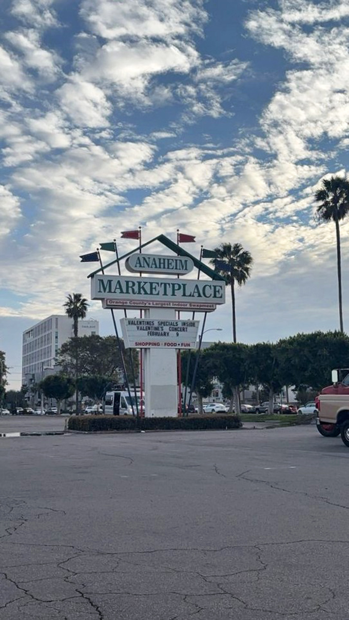 Palm trees frame the iconic sign against California blue skies. This retro marquee stands as a landmark for those in-the-know about Orange County's hidden gems.