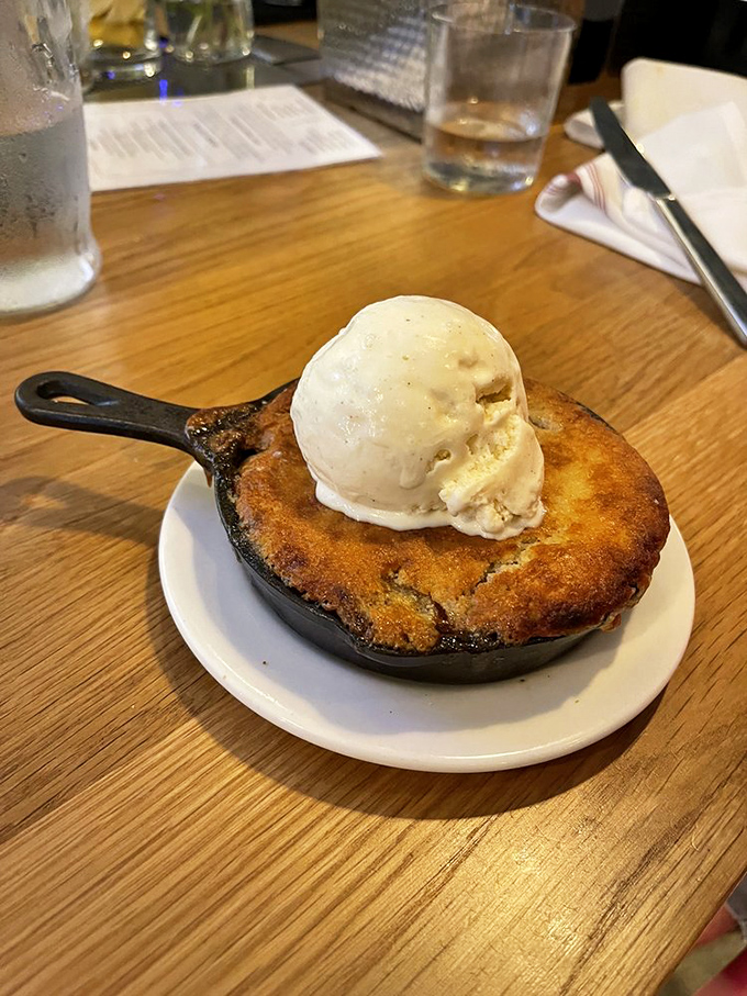 This isn't just dessert—it's a warm hug in cast iron form. The vanilla ice cream performing its magical melting act seals the deal on happiness.