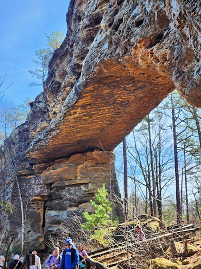 Nature's dramatic limestone balcony defies architectural logic while visitors below ponder how many millennia went into its creation.