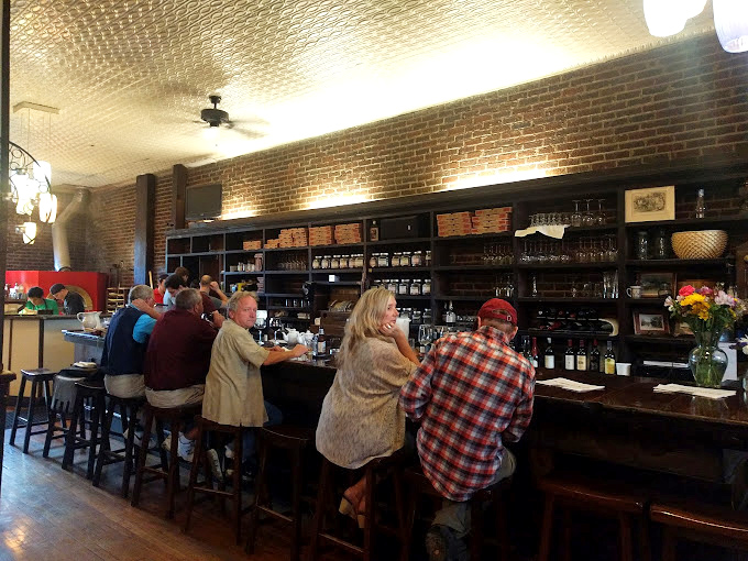 The bar area serves as both social hub and liquid history museum. Those shelves hold spirits almost as interesting as the conversations happening between patrons.