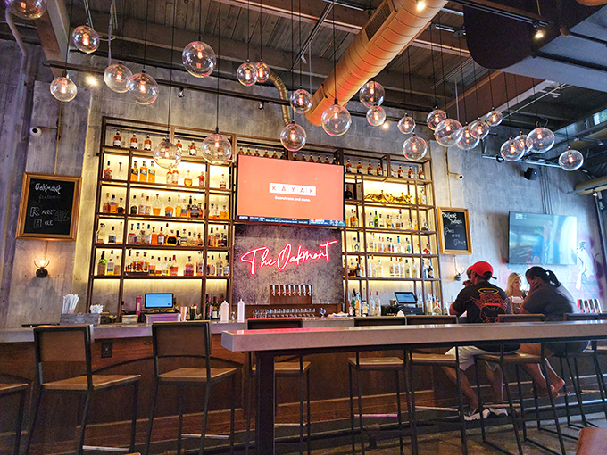 Bar seating that invites lingering. The glowing bottle display isn't just storage&mdash;it's a beacon of hospitality in liquid form.