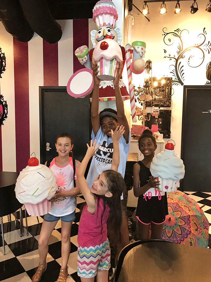 Young candy enthusiasts reaching for oversized decorations, demonstrating the universal truth that Pinkitzel makes kids of us all, regardless of age.