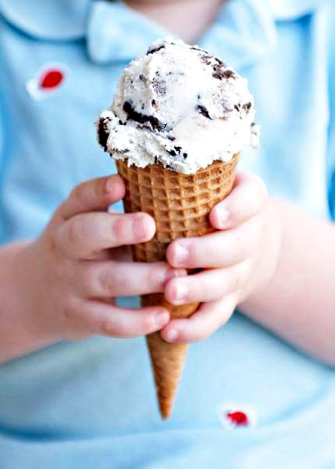 Small hands, big joy—this cookies and cream cone demonstrates why ice cream remains childhood's perfect treat, regardless of your actual age.
