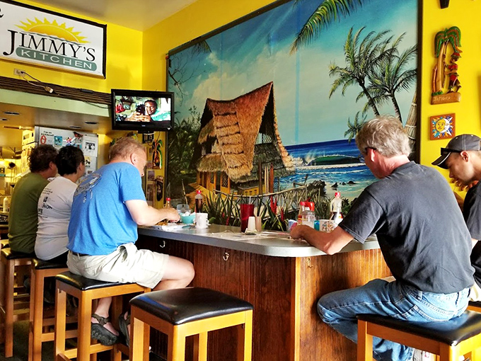 The counter seating offers front-row tickets to the breakfast show, where regulars and beach-goers alike gather under the watchful eye of paradise.