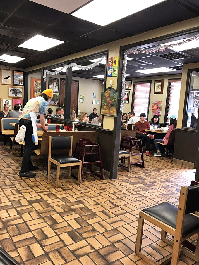 A bustling dining room where strangers become temporary neighbors, united by the universal language of "pass the hot sauce, please."