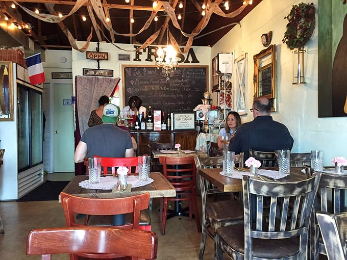 Where mismatched wooden chairs, chalkboard menus, and the French flag create the perfect backdrop for conversations that linger longer than the last sip of wine.