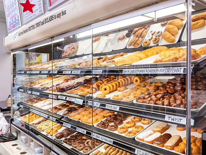 The display case that launched a thousand cravings. Row upon glorious row of handcrafted happiness, each one calling your name in a sugary siren song.