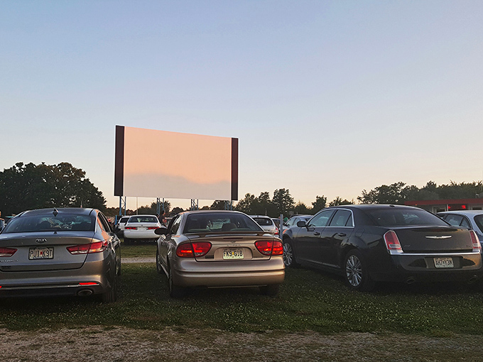 The view from the back row as twilight settles and car taillights glow like fireflies around the massive screen.