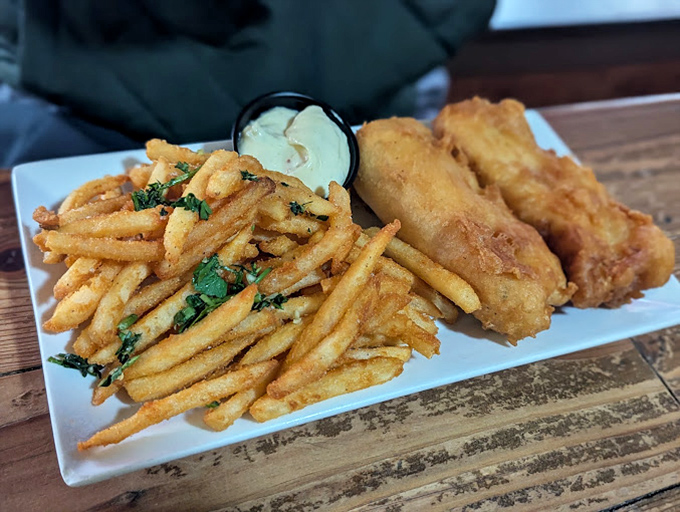 Golden-battered fish with a crunch that could wake the neighbors, alongside fries that make potatoes proud to have sacrificed themselves.