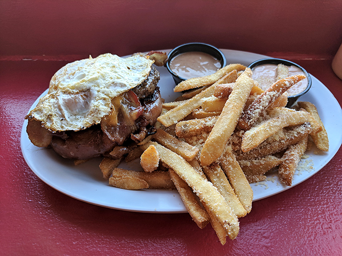 Parmesan-dusted fries with dipping sauces, alongside a burger topped with a sunny-side-up egg. Because sometimes more is exactly the right amount.