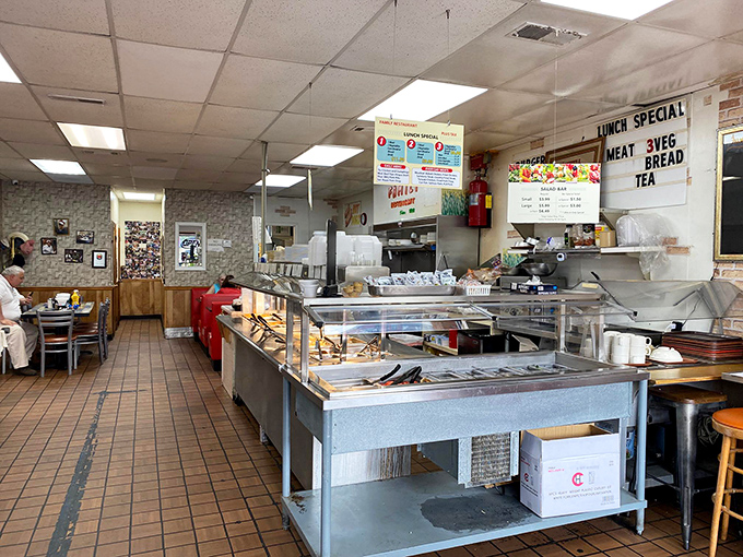 The beating heart of Family Restaurant, where magic happens on a well-seasoned grill. This serving line has witnessed decades of Southern cooking in action.