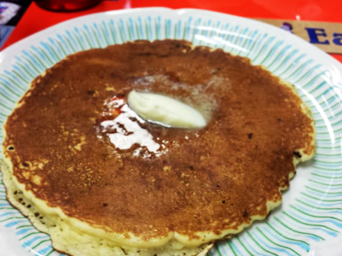 The pancake that launched a thousand road trips. One perfect disc of golden-brown goodness with that telltale puddle of melting butter in the center.