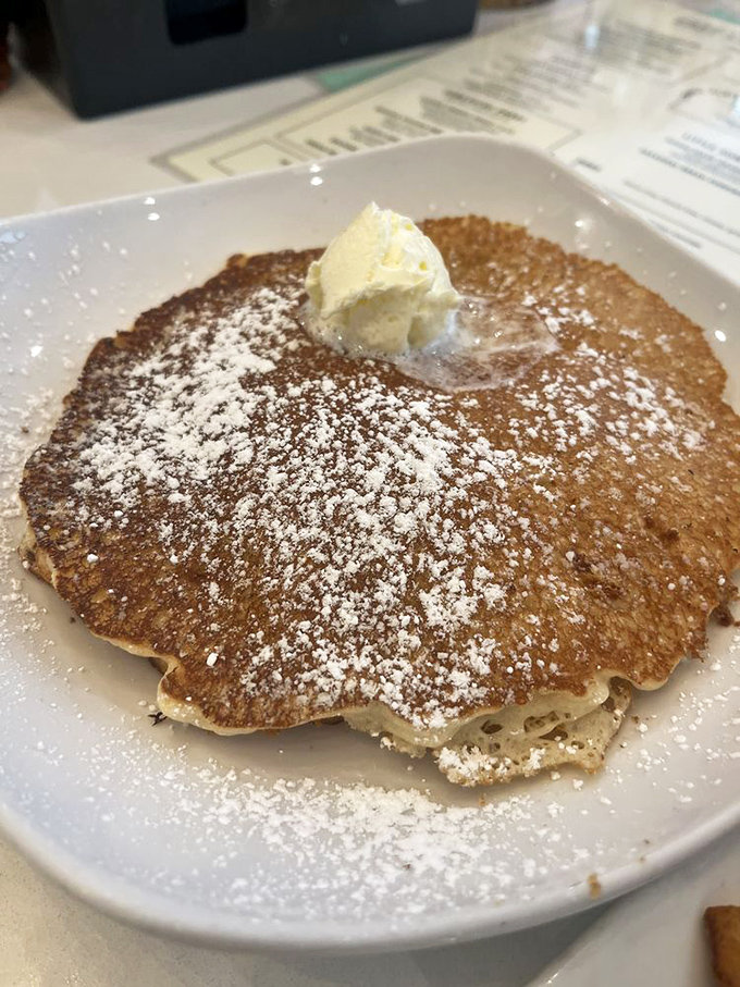 A pancake so perfect it deserves its own ZIP code. That dollop of butter slowly melting is performing the world's most delicious disappearing act.
