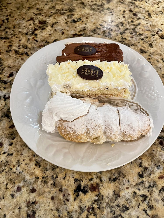 The dessert triple threat&mdash;chocolate &eacute;clair, white cake, and cream puff arranged on a plate that's about to make someone's entire day better.