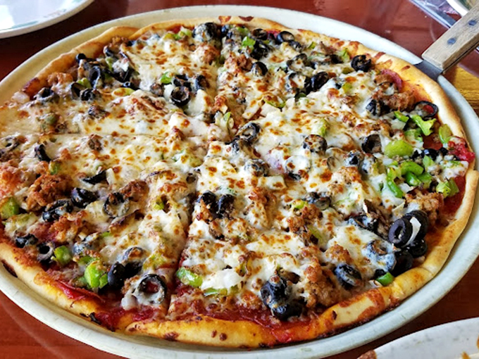 This pizza is the United Nations of toppings&mdash;green peppers, olives, and sausage living together in perfect harmony under a blanket of melted cheese.