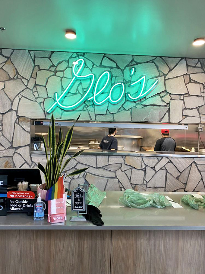 Behind that stone wall and glowing sign, breakfast magicians work their morning alchemy. These are the hands that launch a thousand perfect days.