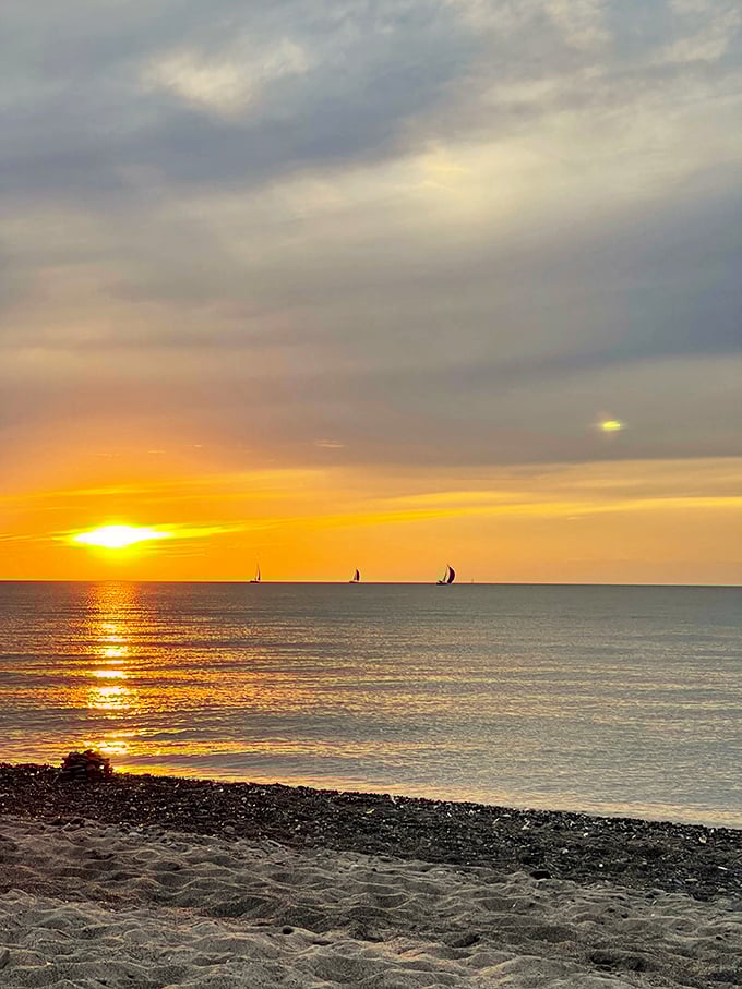 Sunset sailors create silhouettes against Lake Erie's golden hour canvas&mdash;the perfect finale to a day at Ohio's most magnificent beach.