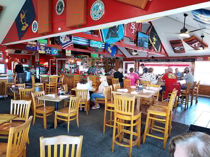 The dining room hums with the satisfied buzz of happy eaters. Red walls and wooden chairs create the perfect backdrop for seafood memories.