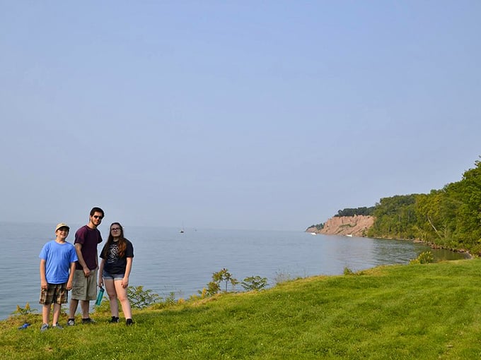 Three visitors pose with the bluffs in the distance, capturing that "we hiked and lived to tell about it" moment for posterity.