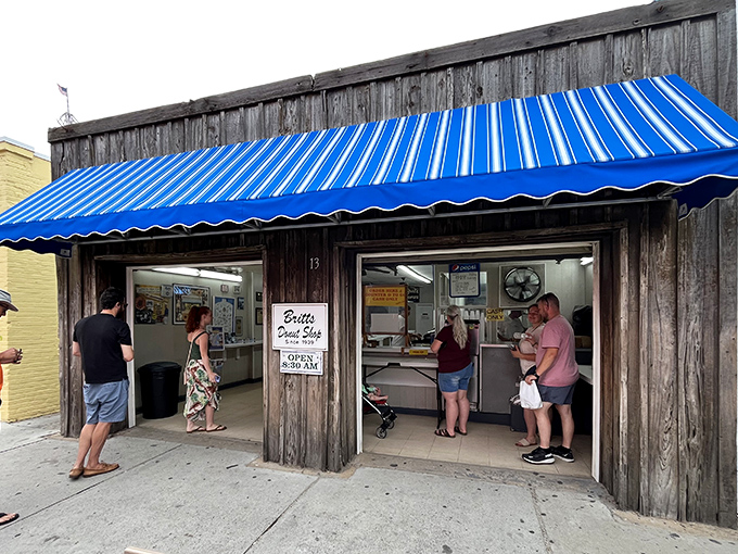 The blue awning of Britt's beckons like a coastal lighthouse, guiding donut lovers to glazed perfection on Carolina Beach.