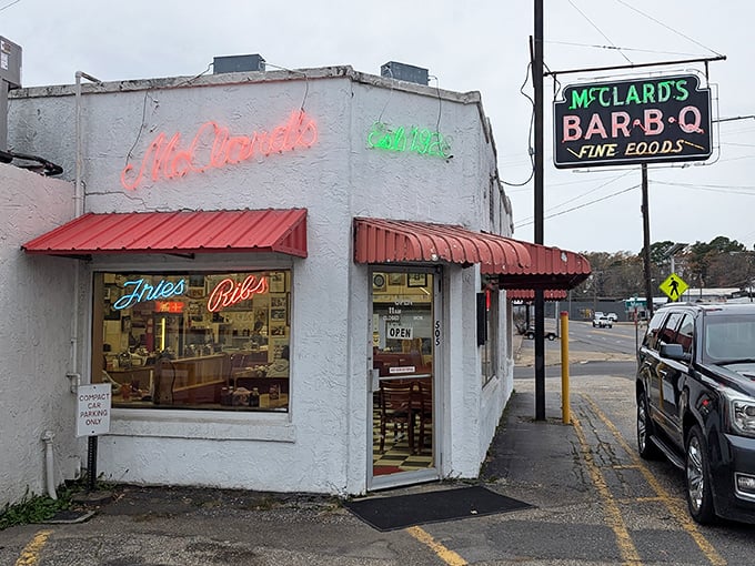 McClard's neon signs beckon like old friends. That red awning promises barbecue magic is happening inside!