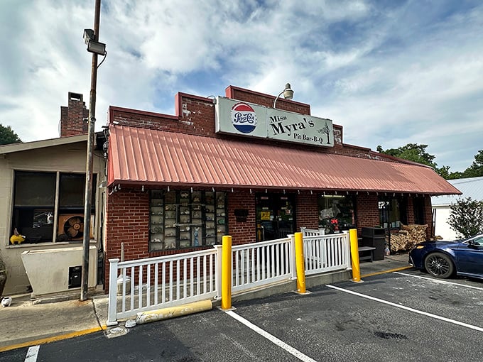 Miss Myra's exterior beckons with its humble brick facade and red awning &ndash; proof that BBQ greatness often hides in plain sight.