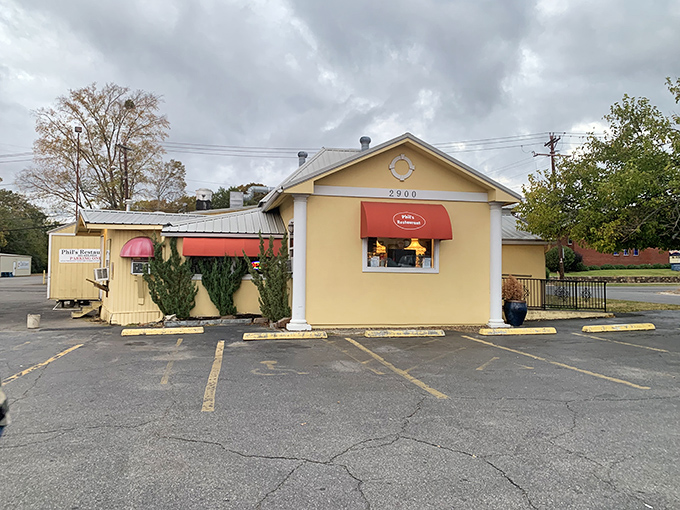 The sunny yellow exterior of Phil's Restaurant promises comfort food magic behind that cheerful red awning.