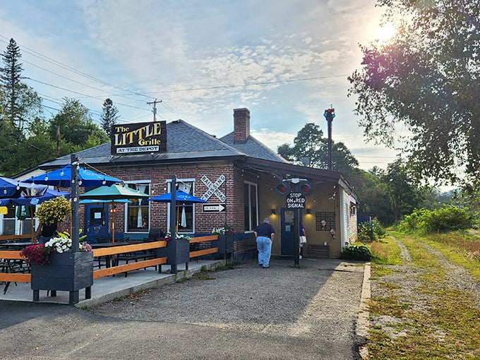 The Little Grille's brick exterior and blue picnic tables promise a sandwich experience worth stopping a train for.