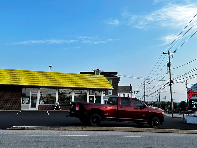 The bright orange awning of Peace, Love and Little Donuts beckons like a sugary lighthouse in a sea of brick buildings.