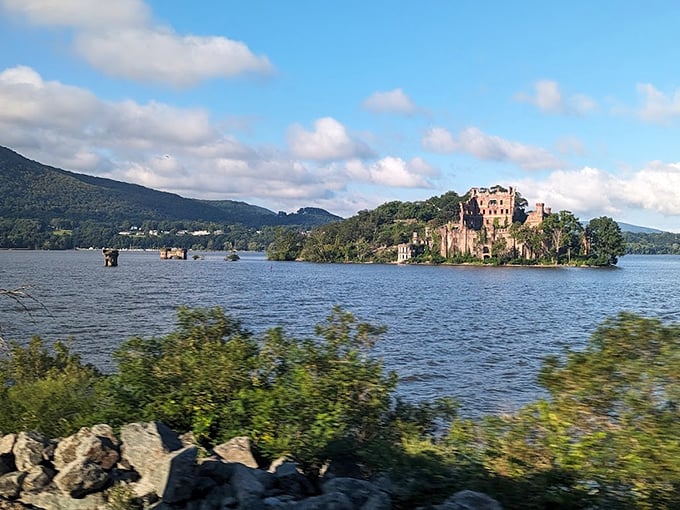 The Hudson River serves as nature's mirror, perfectly reflecting this majestic castle ruin that seems transported from medieval Scotland.