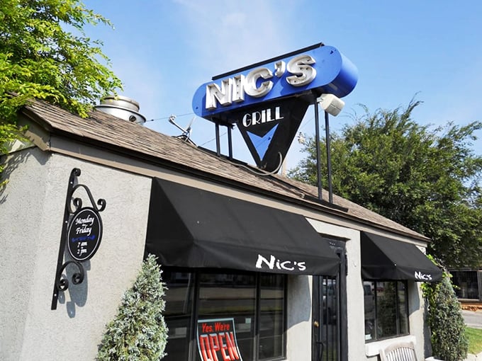 The blue Nic's Grill sign beckons burger pilgrims like a neon North Star. Small in size, colossal in flavor.