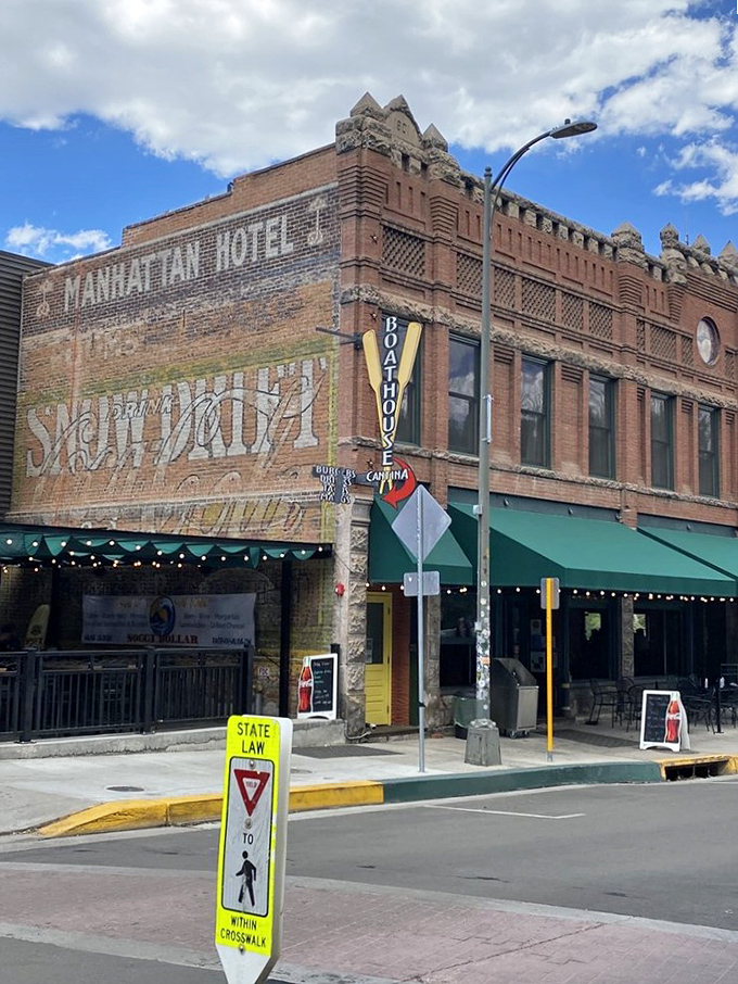 The Manhattan Hotel building now houses the Boathouse Cantina, where riverside dining meets mountain town charm. That green awning practically whispers, "Come sit a while."