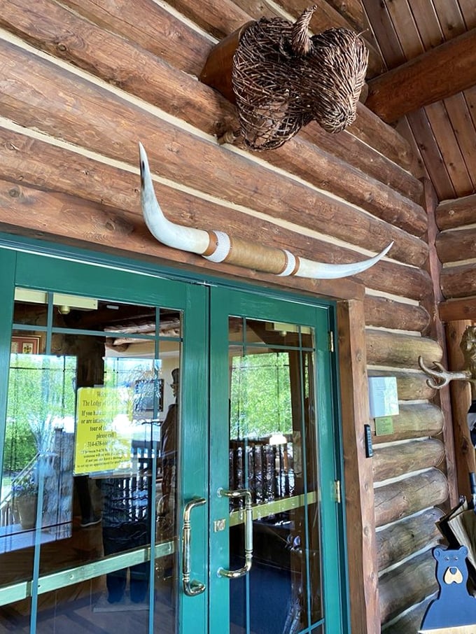 Where wilderness meets welcome: Natural wood beams frame the entryway while rustic decor hints at the authentic lodge experience awaiting inside.