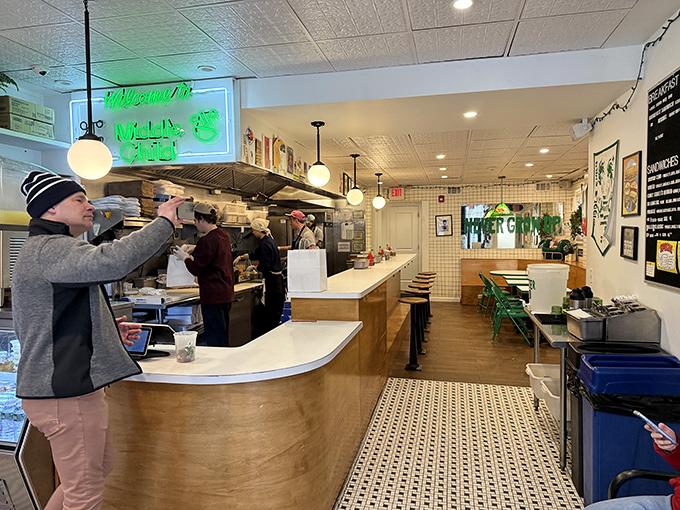 The bright, airy interior combines minimalist design with playful pops of green, creating a space that feels both modern and instantly welcoming.