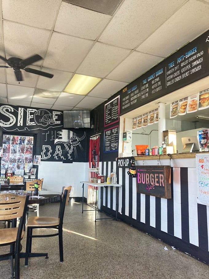Black and white striped counter with "Siege the Day" wall art creates an unpretentious atmosphere where serious burger business happens.