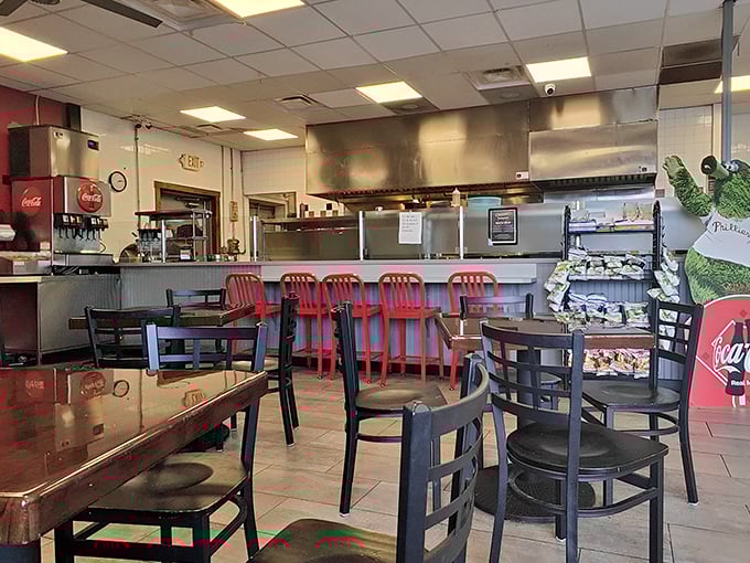 No-frills dining at its finest—those red chairs aren't just furniture, they're front-row seats to the sandwich symphony happening behind the counter.