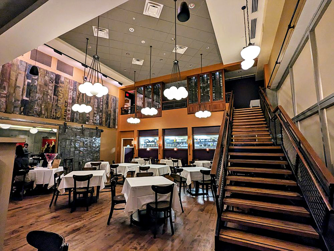 Soaring ceilings, elegant staircases, and cloud-like pendant lights create an atmosphere that says "yes, you're treating yourself tonight" without a hint of stuffiness.