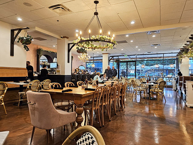 Chandeliers adorned with greenery cast a golden glow over the dining room, where bistro chairs invite you to settle in for the long haul.