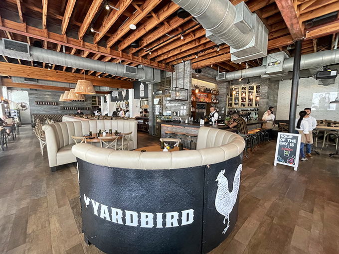 Exposed wooden beams meet industrial chic in this dining room where comfort meets sophistication. The circular host stand proudly displays the restaurant's feathered mascot.